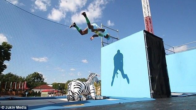 Acrobat shows amazing skills on the trampoline, while riding a rubber ...