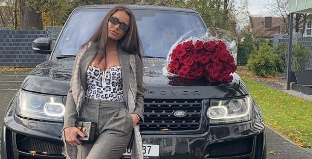 Genta poses very stylishly next to a luxury car, while her young ...