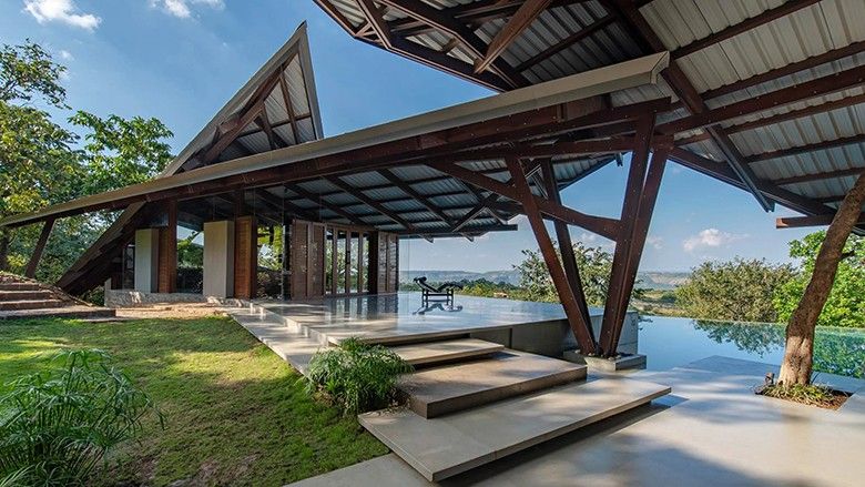 A house with a large veranda, a very large pool and an unusual roof ...