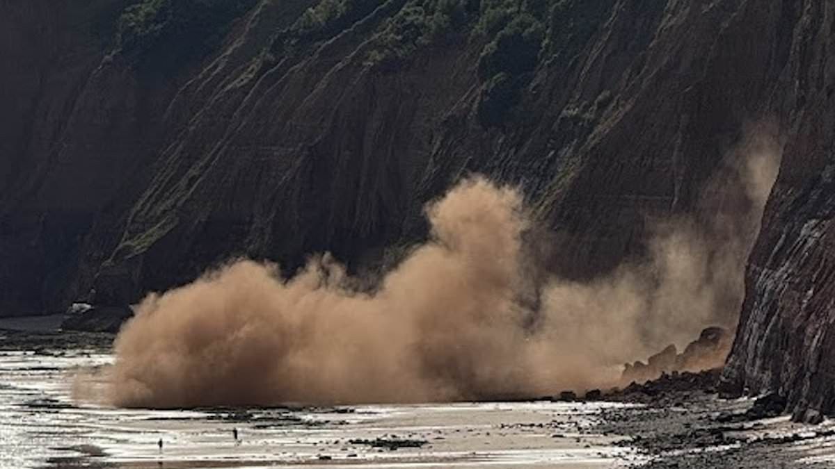 Thousands of tons of stones fall from the cliff on a beach in Britain ...